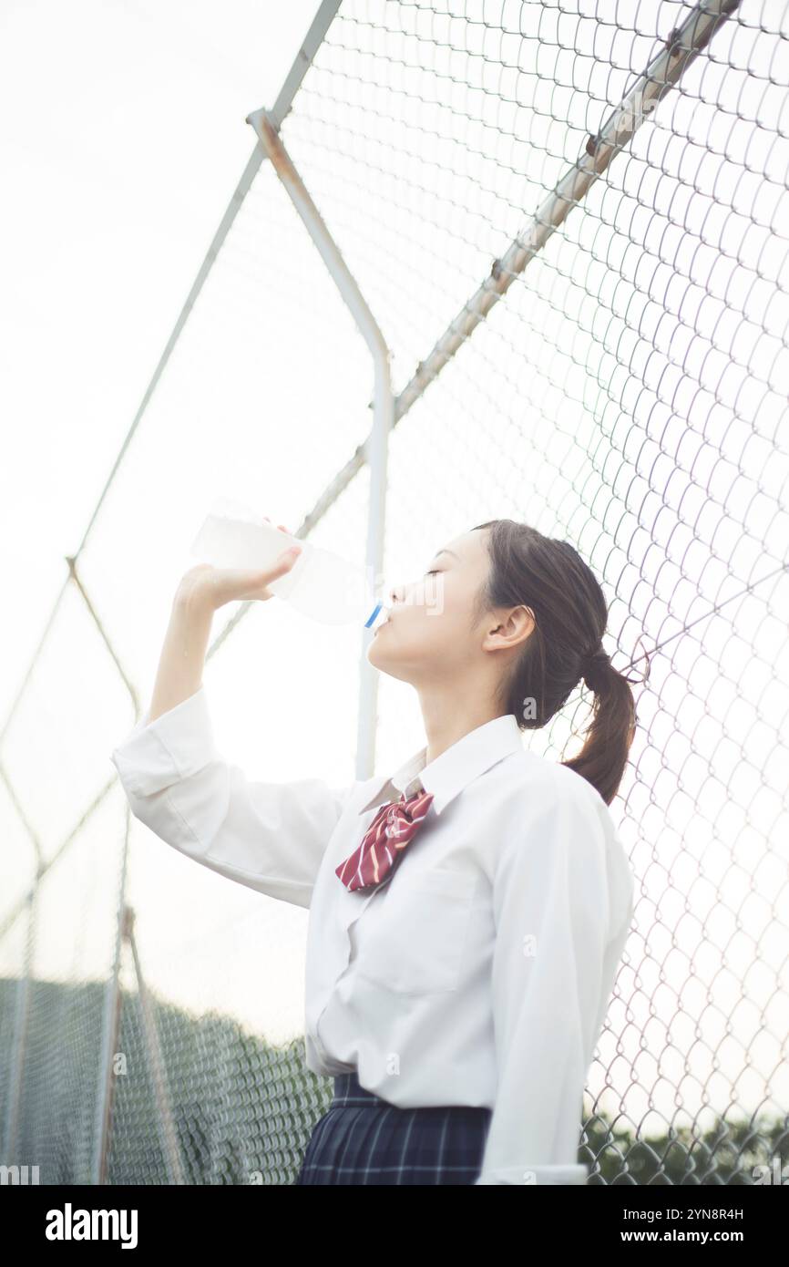 High school girl drinking from a plastic bottle Stock Photo - Alamy