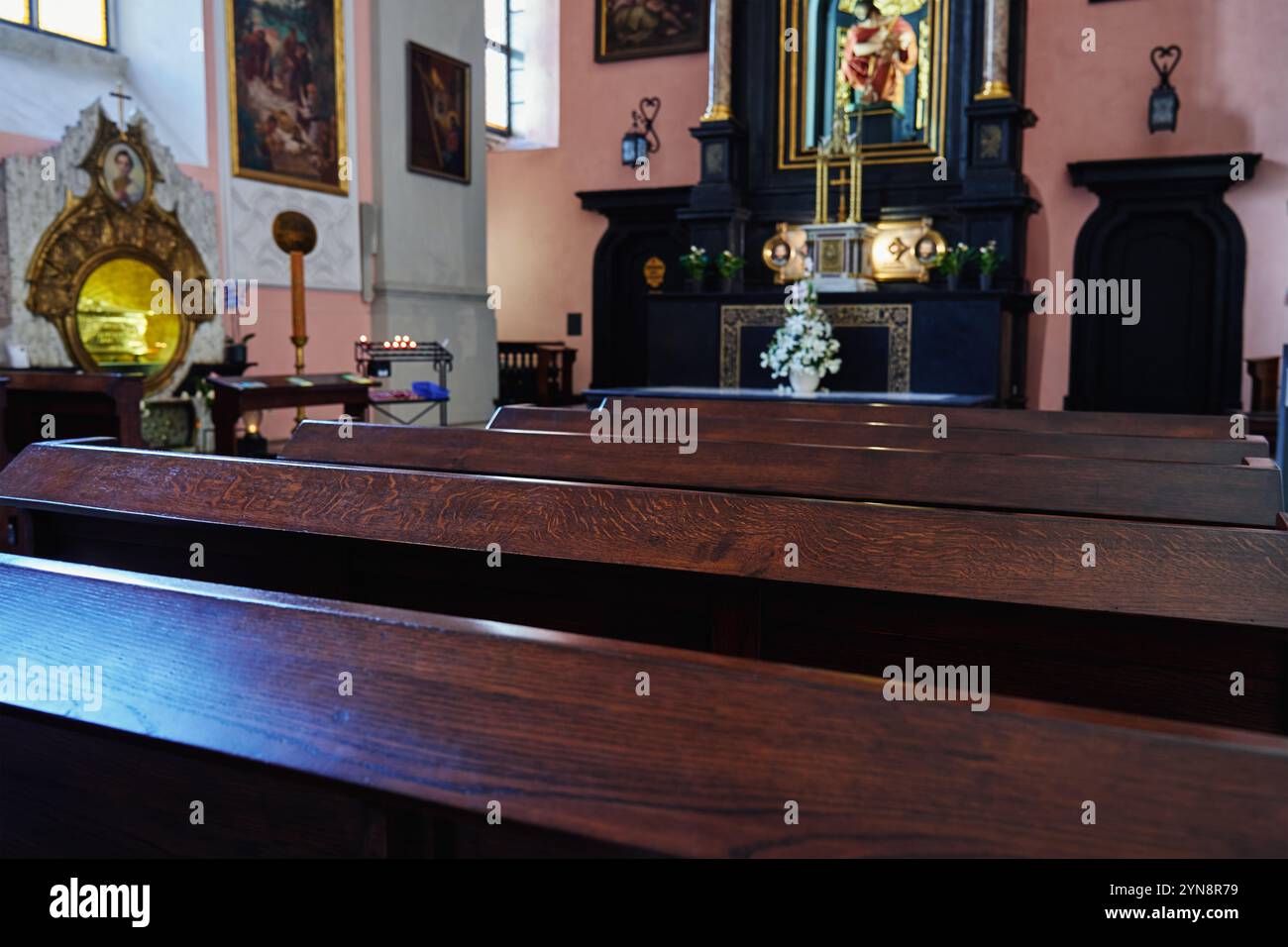 Interior of catholic church with wooden pews and altar in background ...