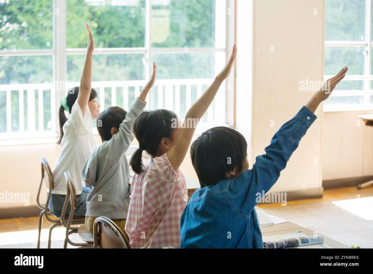 Back view of schoolchildren raising their hands Stock Photo - Alamy