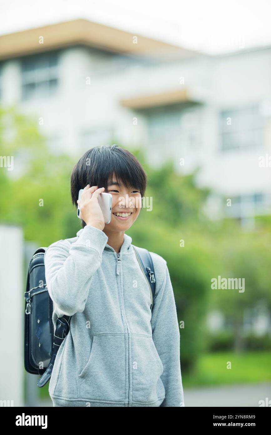 Smiling schoolboy making a phone call Stock Photo - Alamy