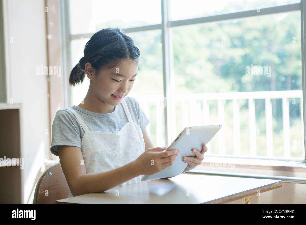 Girls using tablets in the classroom Stock Photo - Alamy