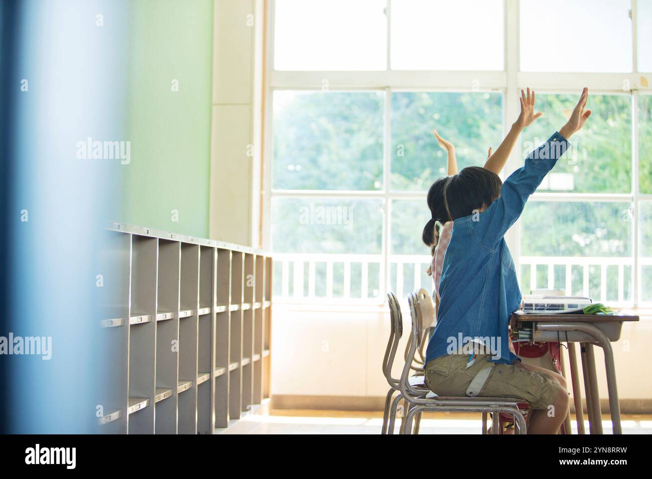 Primary schools children raising their hands Stock Photo - Alamy