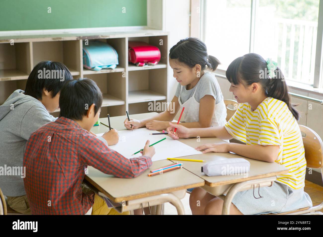 Primary schools students studying in a group Stock Photo - Alamy