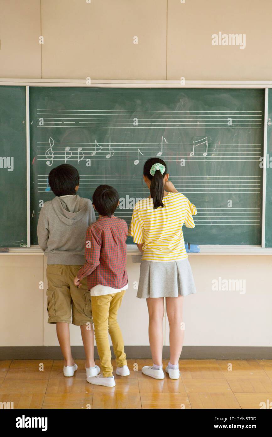 Primary school children drawing notes on the music room wall Stock ...