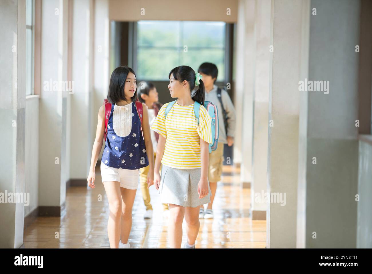Primary schools students walking in corridor Stock Photo - Alamy