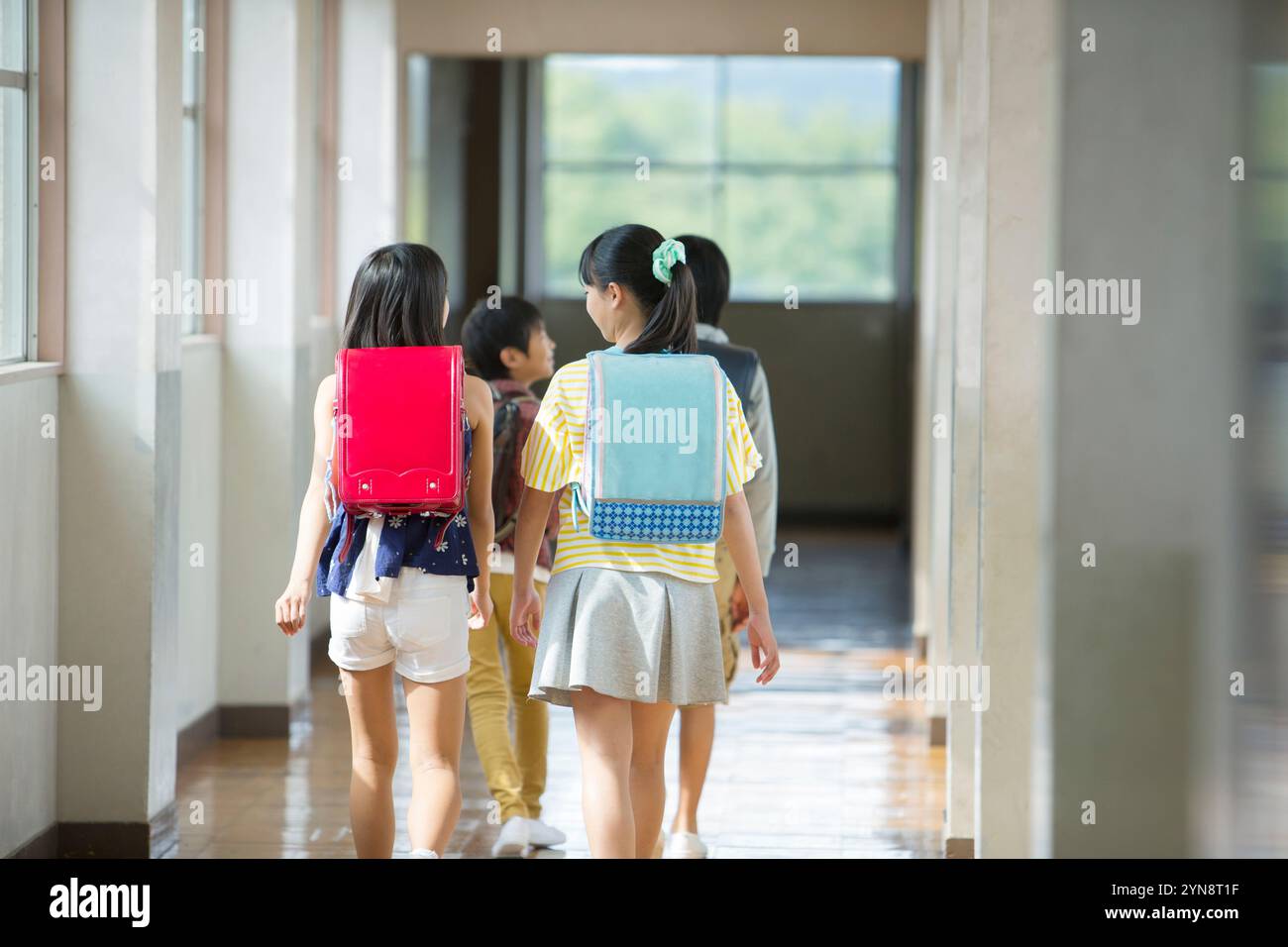 Back view of primary schools students walking in corridor Stock Photo ...