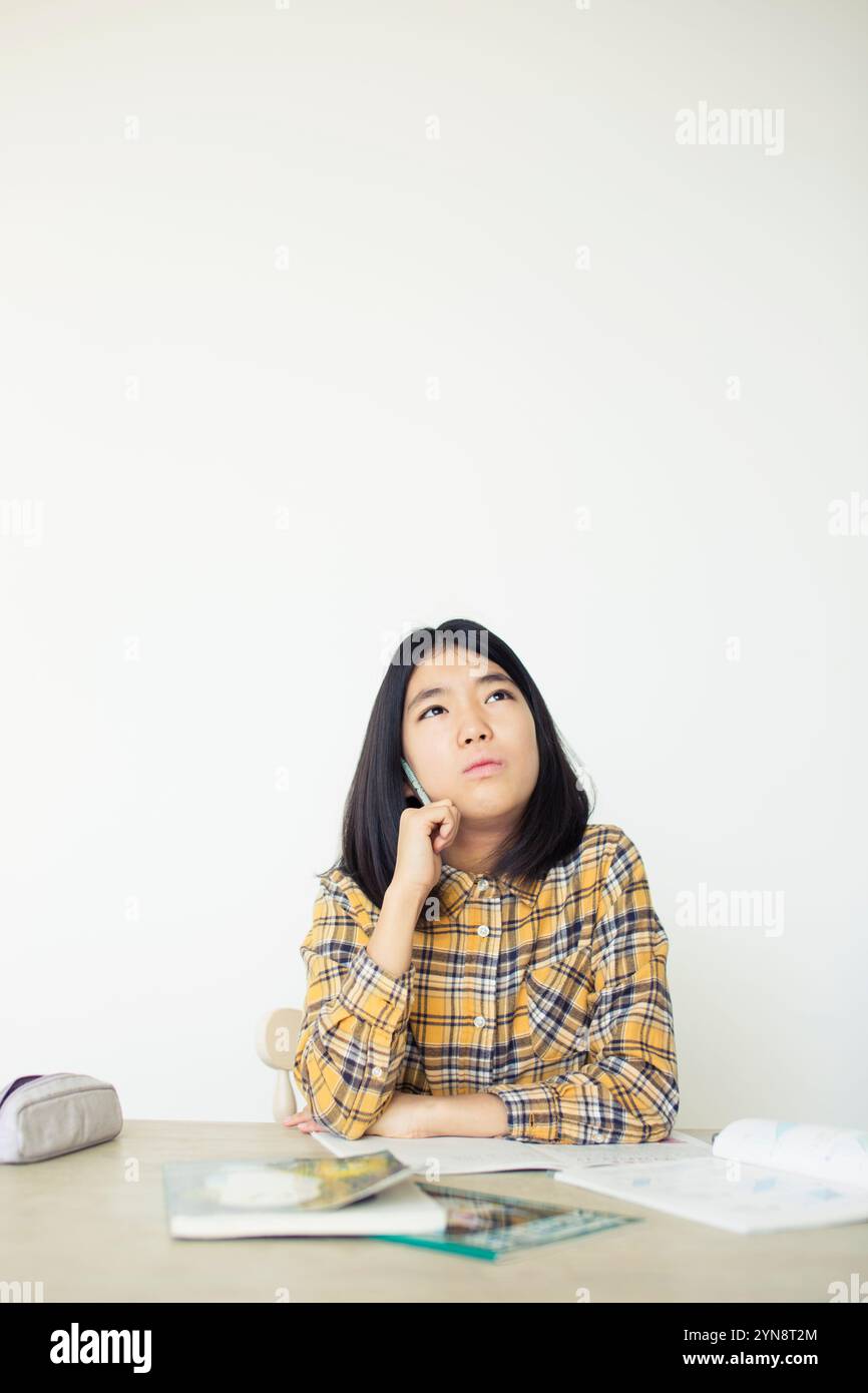 A primary school girl thinking while studying Stock Photo - Alamy