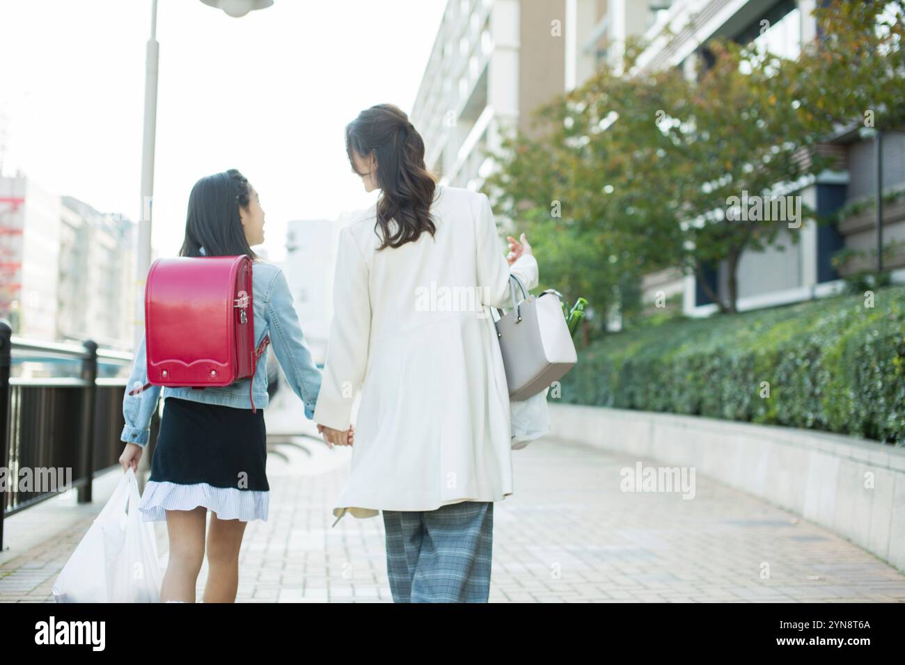 Back view of parent and child walking in the street Stock Photo - Alamy