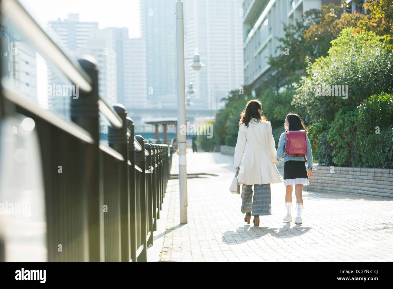 Back view of parent and child walking in the street Stock Photo - Alamy