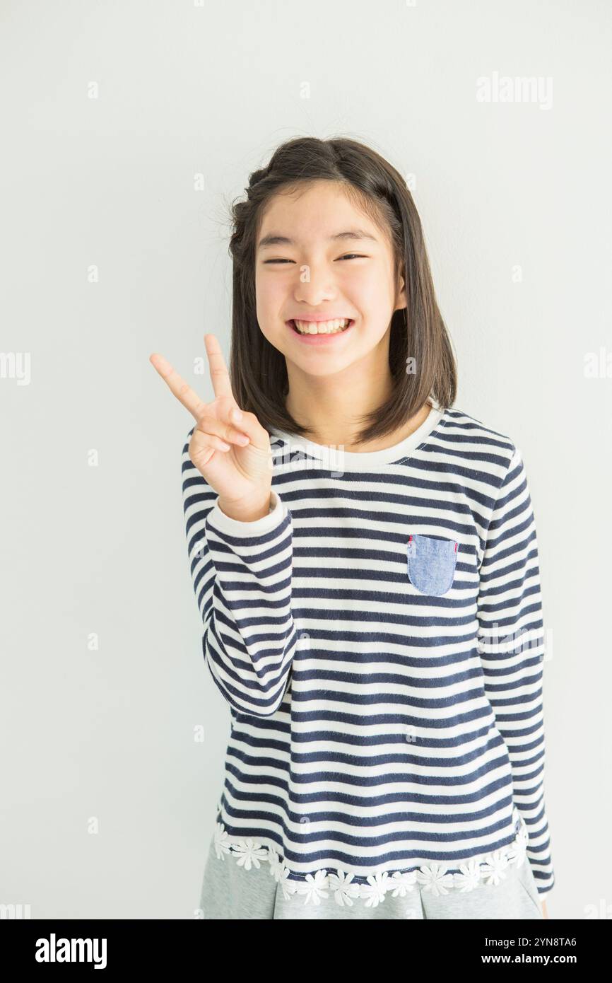 Portrait of smiling primary school girl making peace sign Stock Photo ...