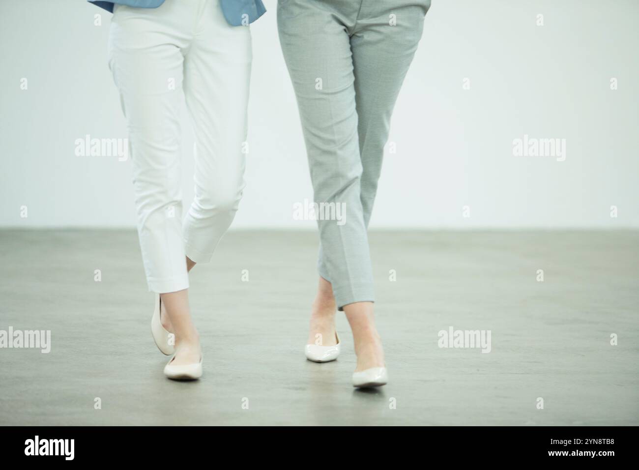 Two walking women on their feet Stock Photo - Alamy