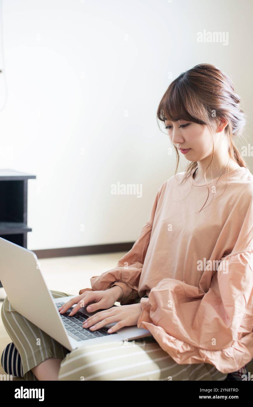 Women in their 20s operating a computer in a room Stock Photo - Alamy