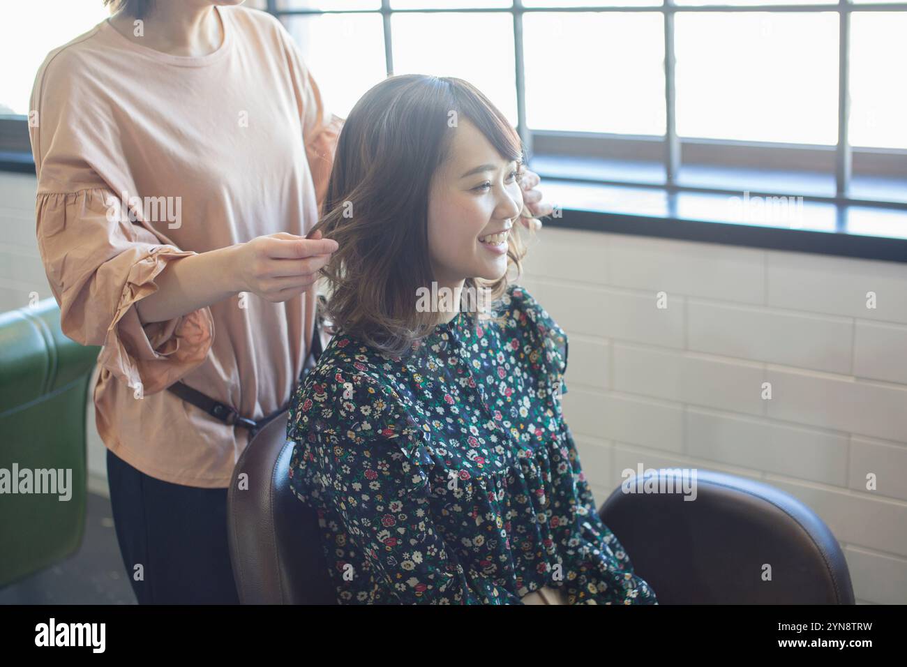 Smiling 20s woman getting a styling at a beauty salon Stock Photo - Alamy