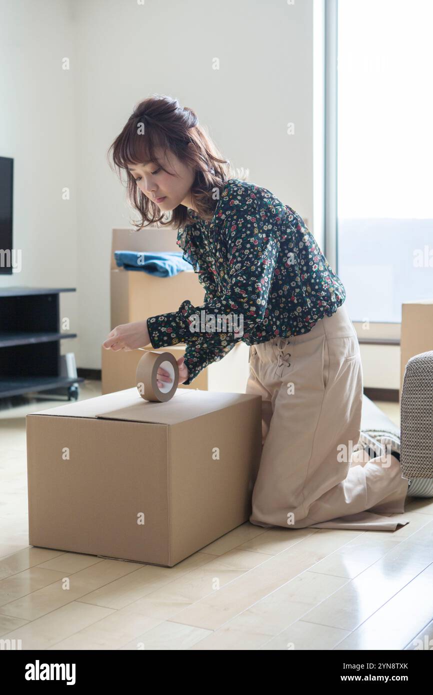 Woman in her 20s packing cardboard boxes Stock Photo - Alamy