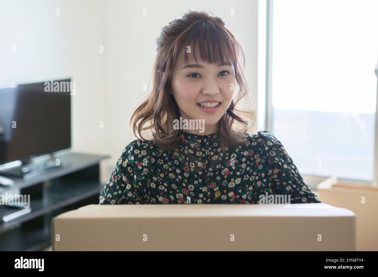 Woman in her 20s carrying a packed parcel Stock Photo - Alamy