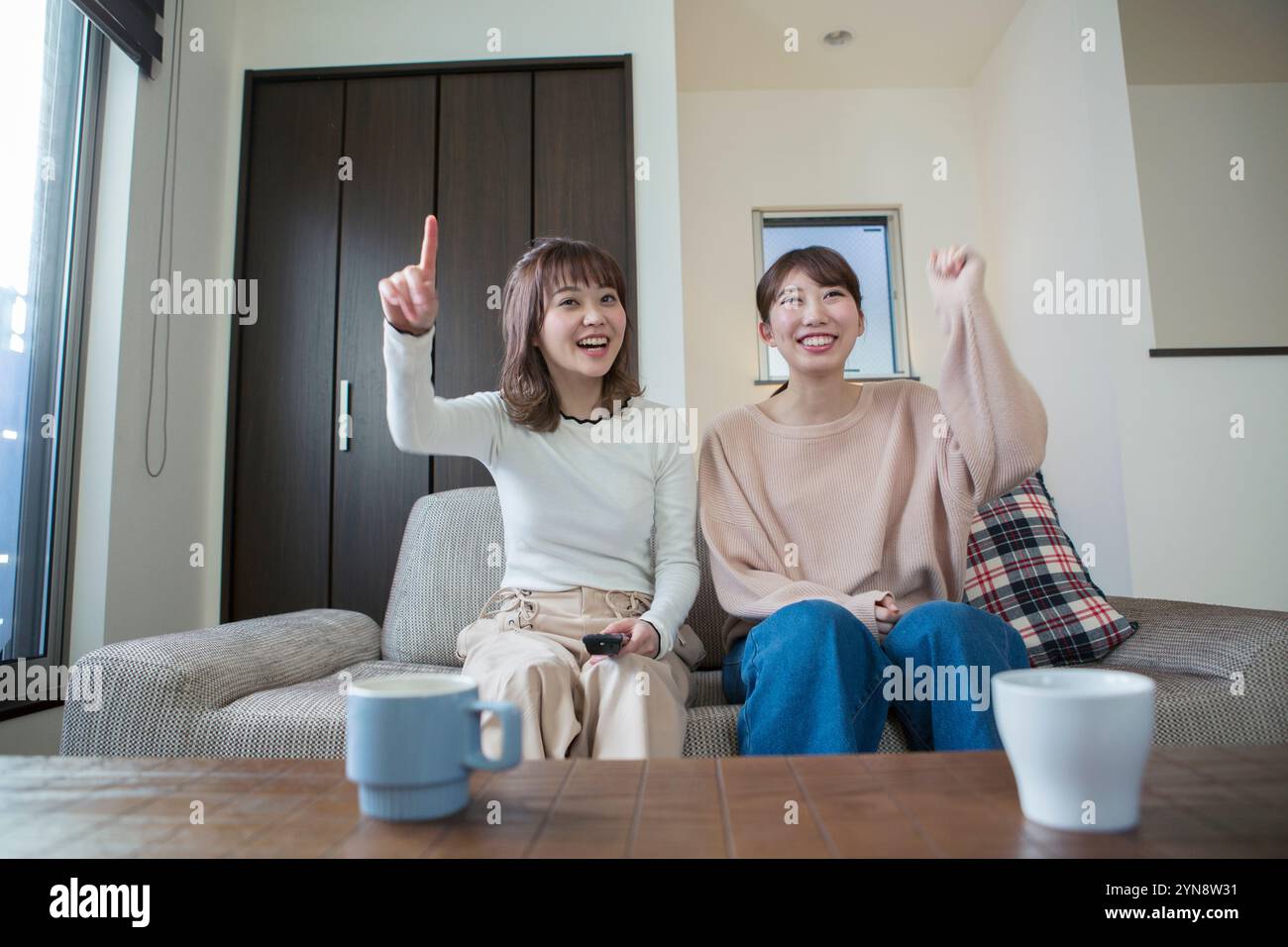 Two women in their 20s enjoying watching sports Stock Photo - Alamy