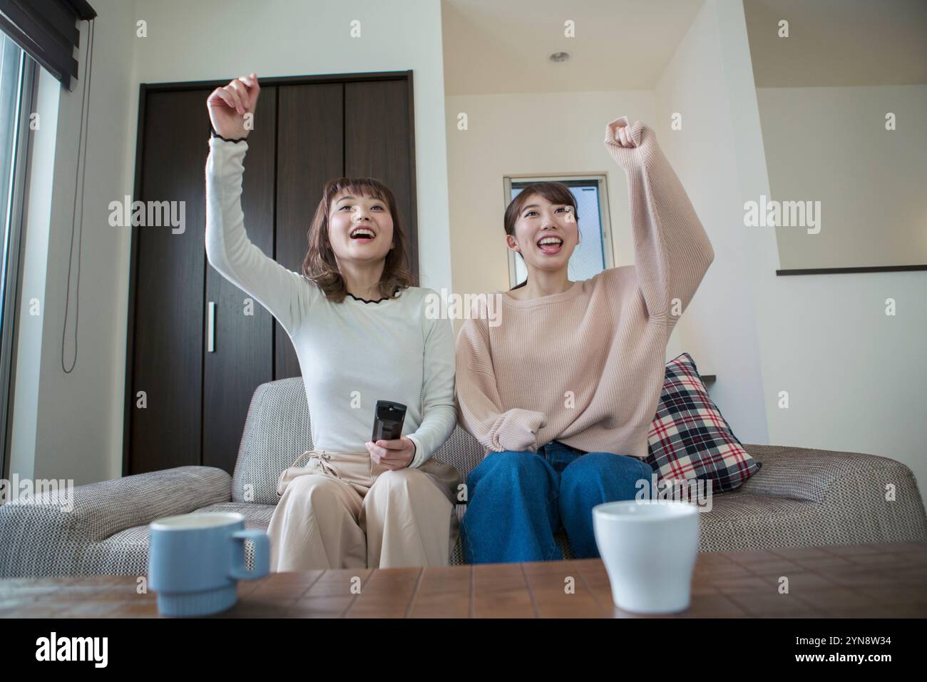 Two women in their 20s enjoying watching sports Stock Photo - Alamy