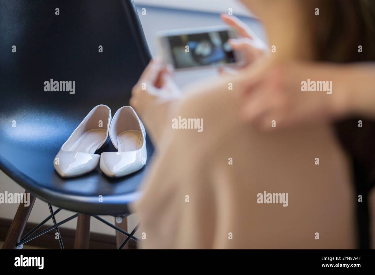 Back view of woman taking a photo of pumps Stock Photo - Alamy