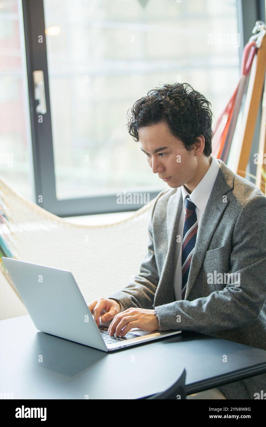 Male in his 20s operating a computer Stock Photo - Alamy