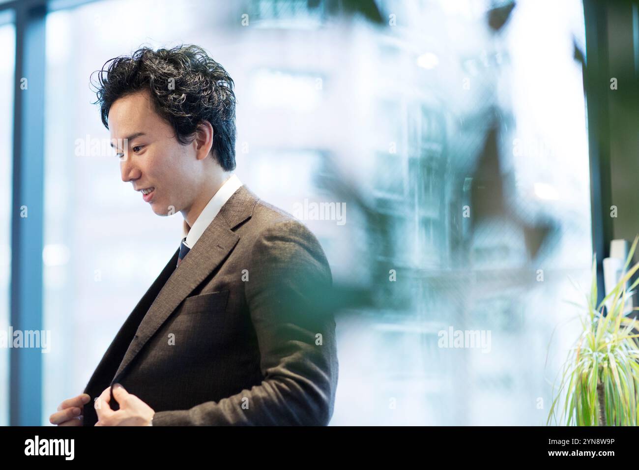 Smiling 20s man with his arm through his jacket Stock Photo - Alamy