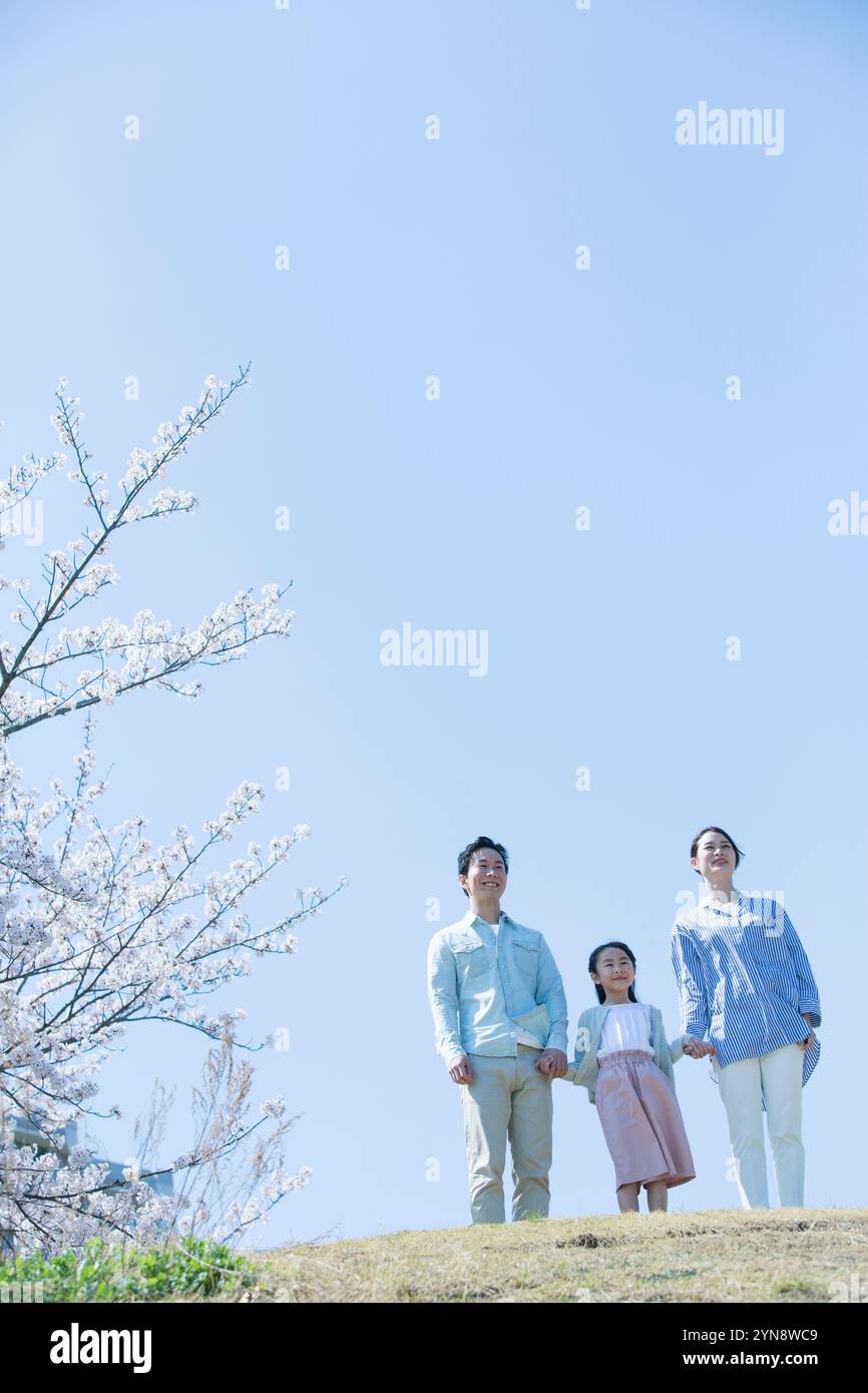 Happy family standing under a cherry tree Stock Photo - Alamy