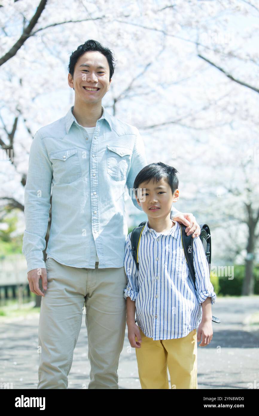 Portrait of smiling parents and children standing under a cherry tree ...