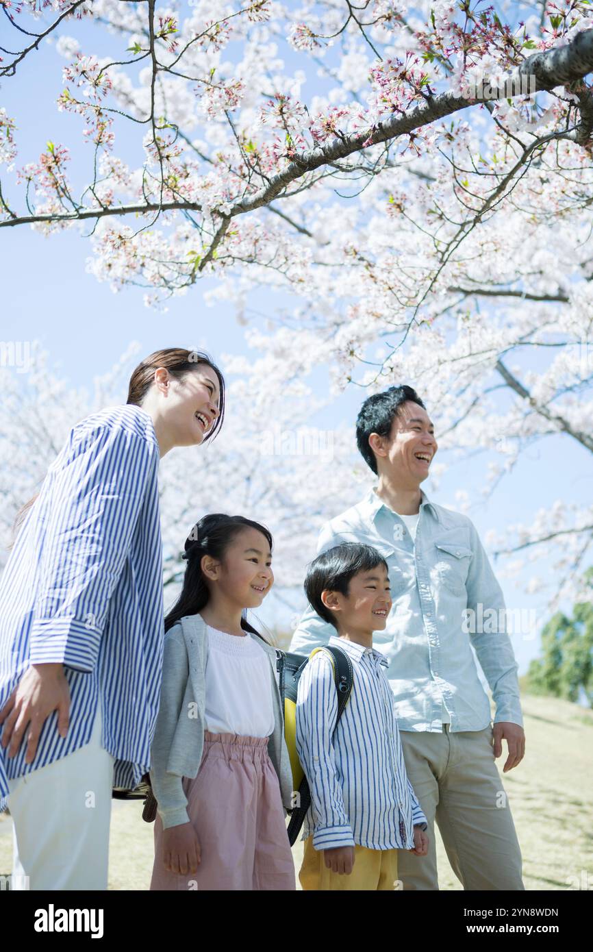Happy family standing under a cherry tree Stock Photo - Alamy
