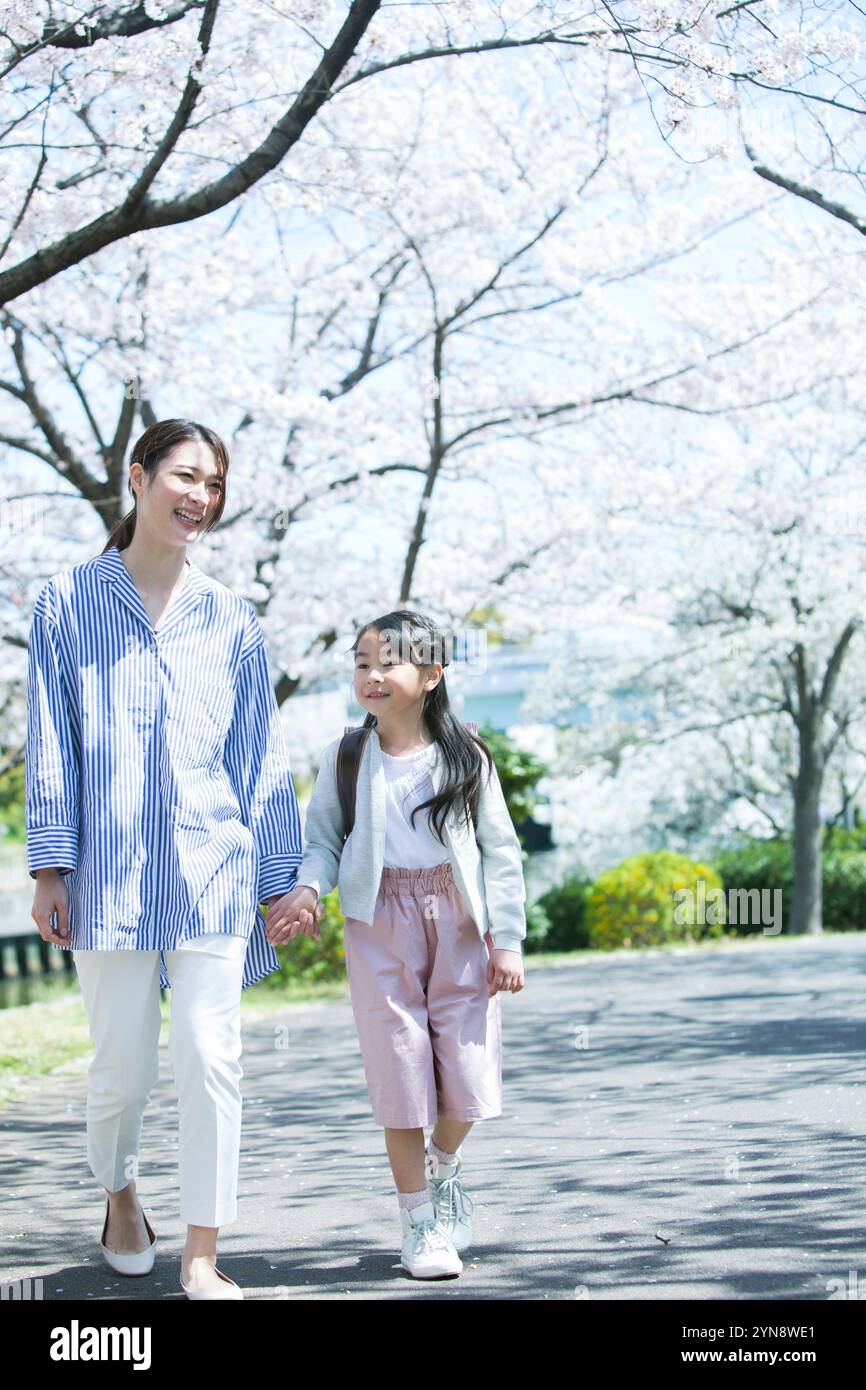 Smiling parents and children walking under a cherry tree Stock Photo ...