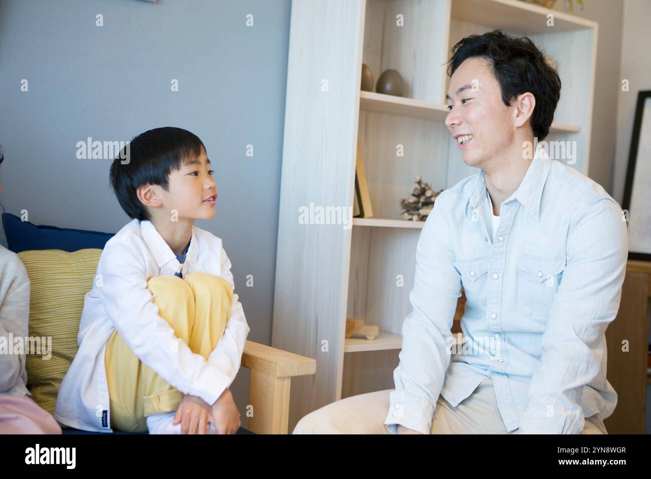 Smiling parents and children talking in room Stock Photo - Alamy