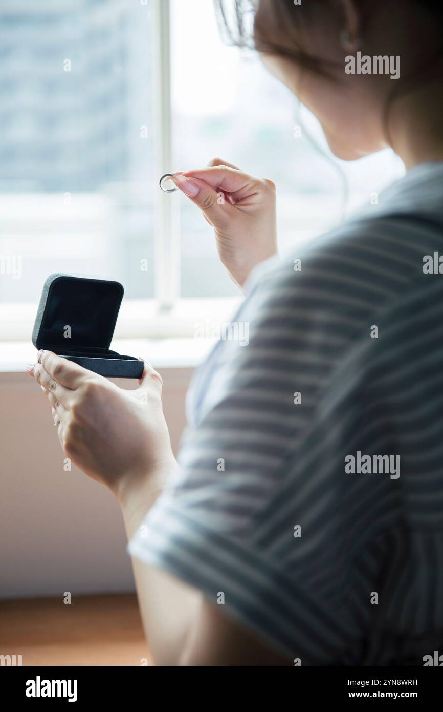 Back view of a woman taking a ring out of a ring case Stock Photo - Alamy