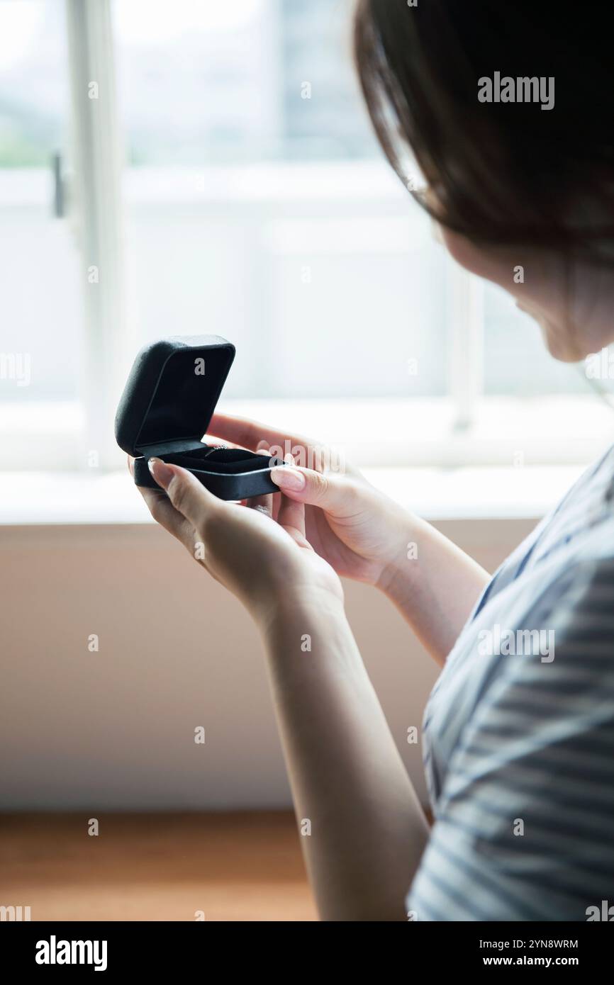 Back view of a woman taking a ring out of a ring case Stock Photo - Alamy