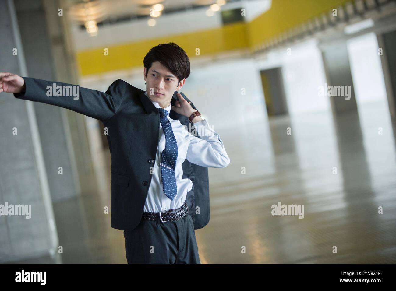Man in his 20s with his arm through his jacket Stock Photo - Alamy