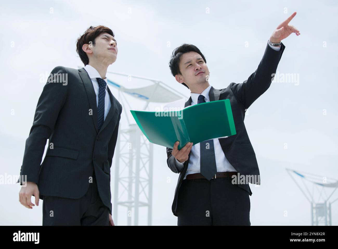 Two men in their 20s in suits standing on a building street Stock Photo ...