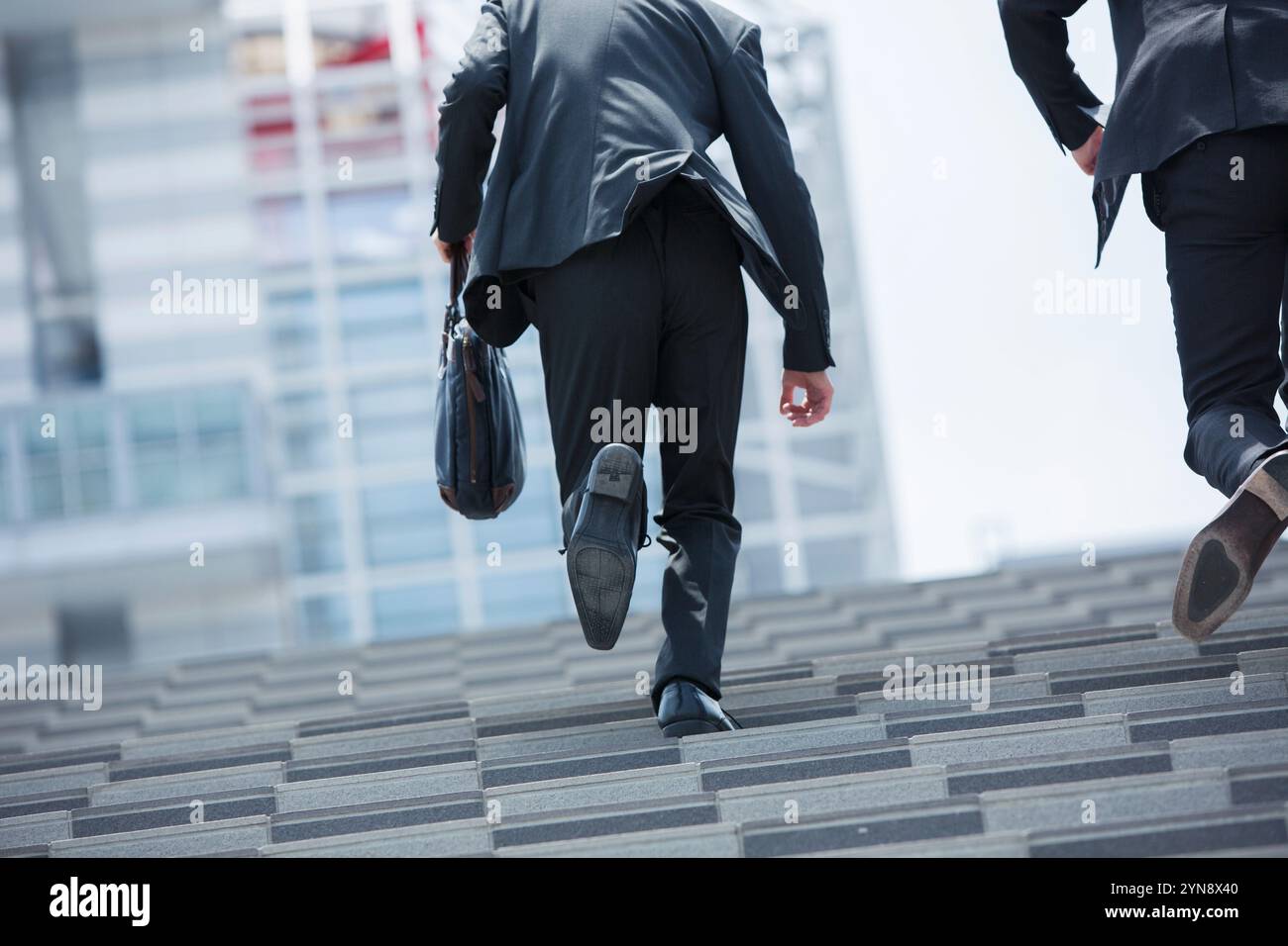 Two men in their 20s in suits ascending stairs Stock Photo - Alamy