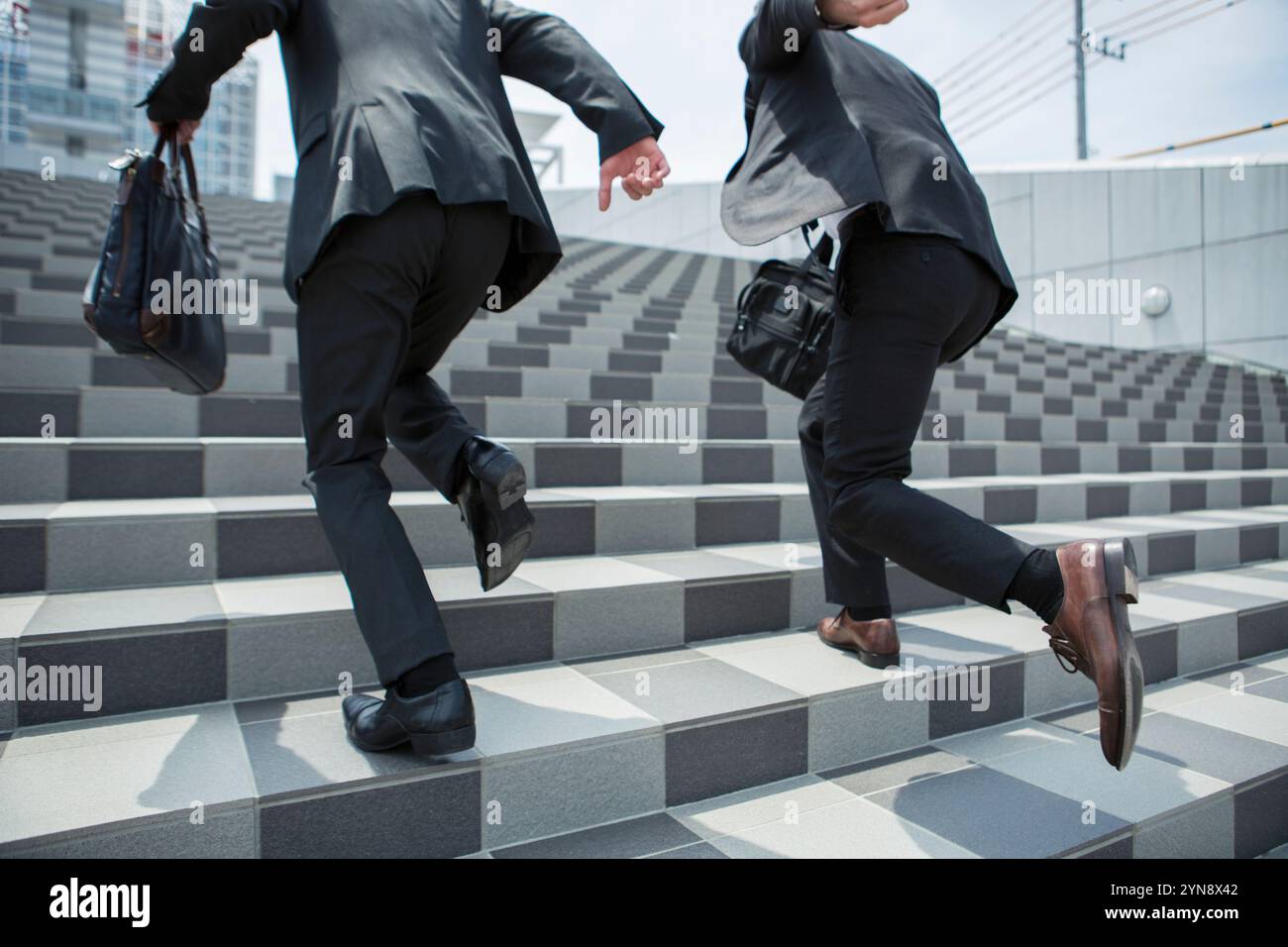 Two men in their 20s in suits ascending stairs Stock Photo - Alamy