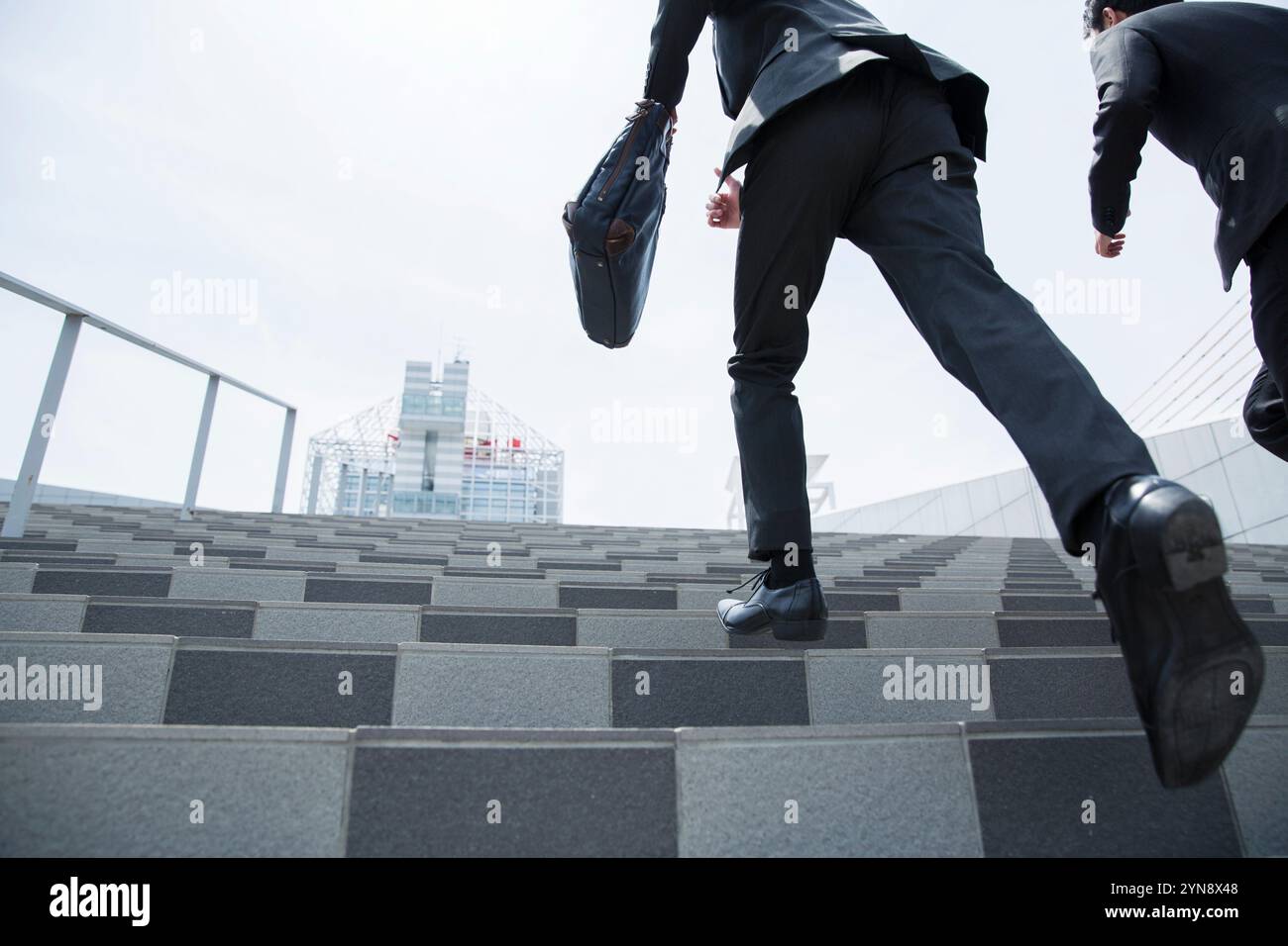 Two men in their 20s in suits ascending stairs Stock Photo - Alamy