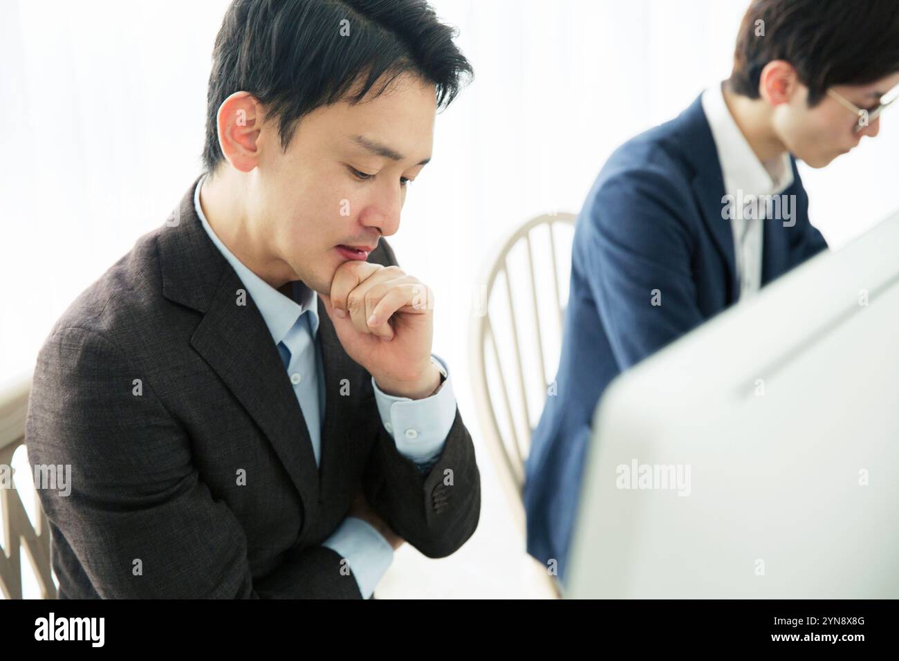 Man in his 20s thinking in front of computer Stock Photo - Alamy