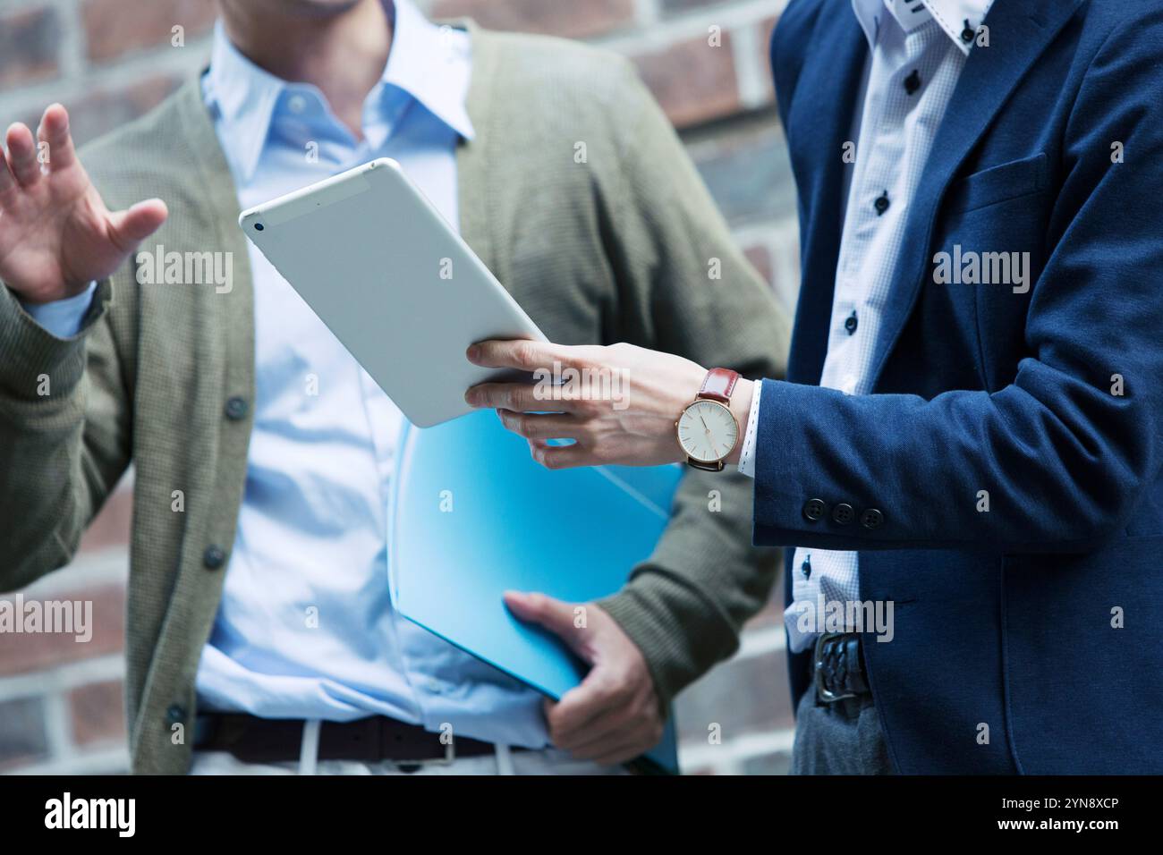 Two men holding and explaining the tablet Stock Photo - Alamy