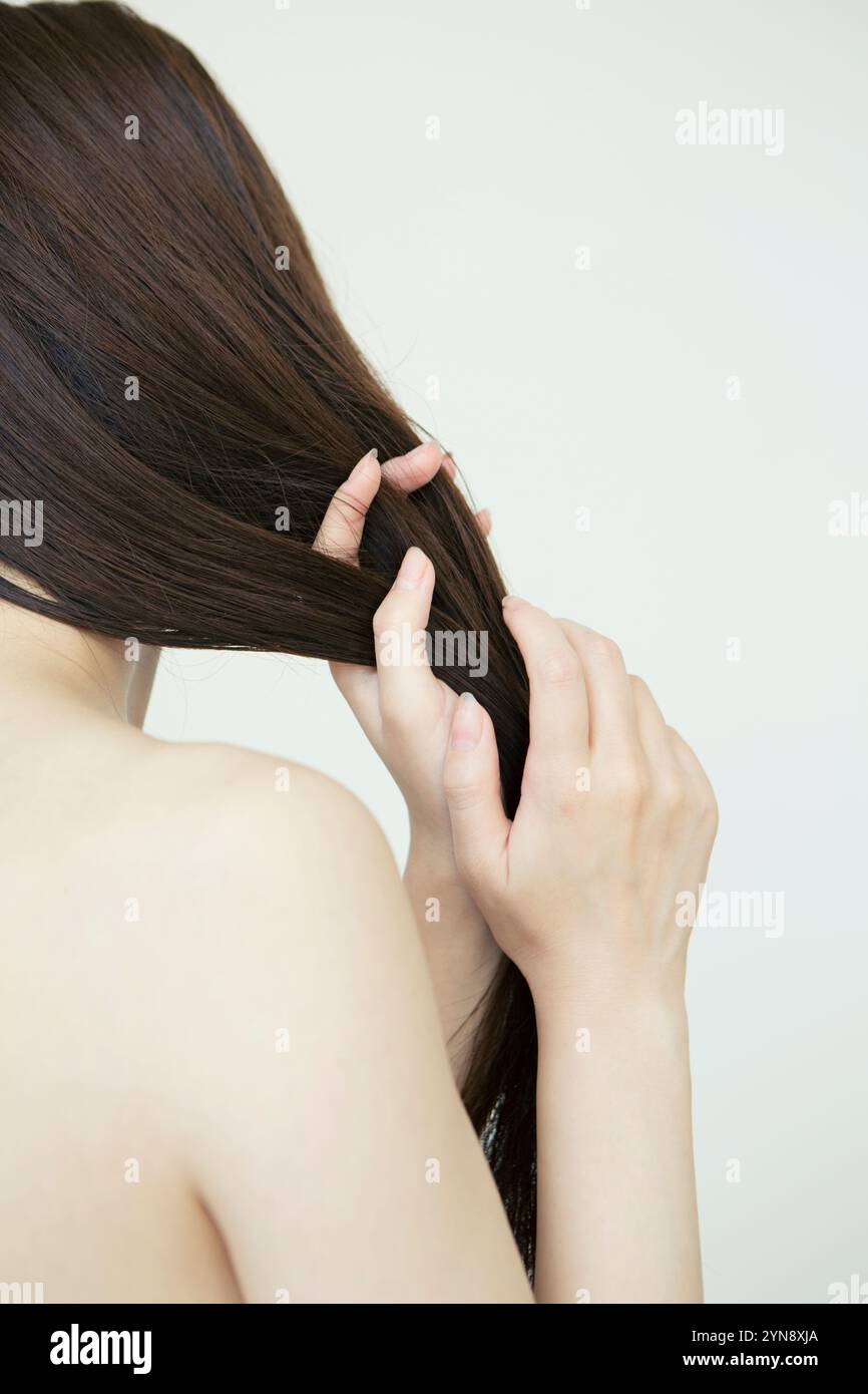 Back view of woman touching her own hair Stock Photo - Alamy