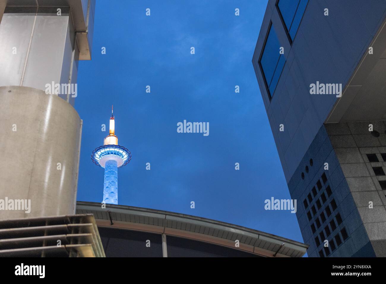 Kyoto Tower Illuminated at Twilight Between Modern Architecture Stock ...
