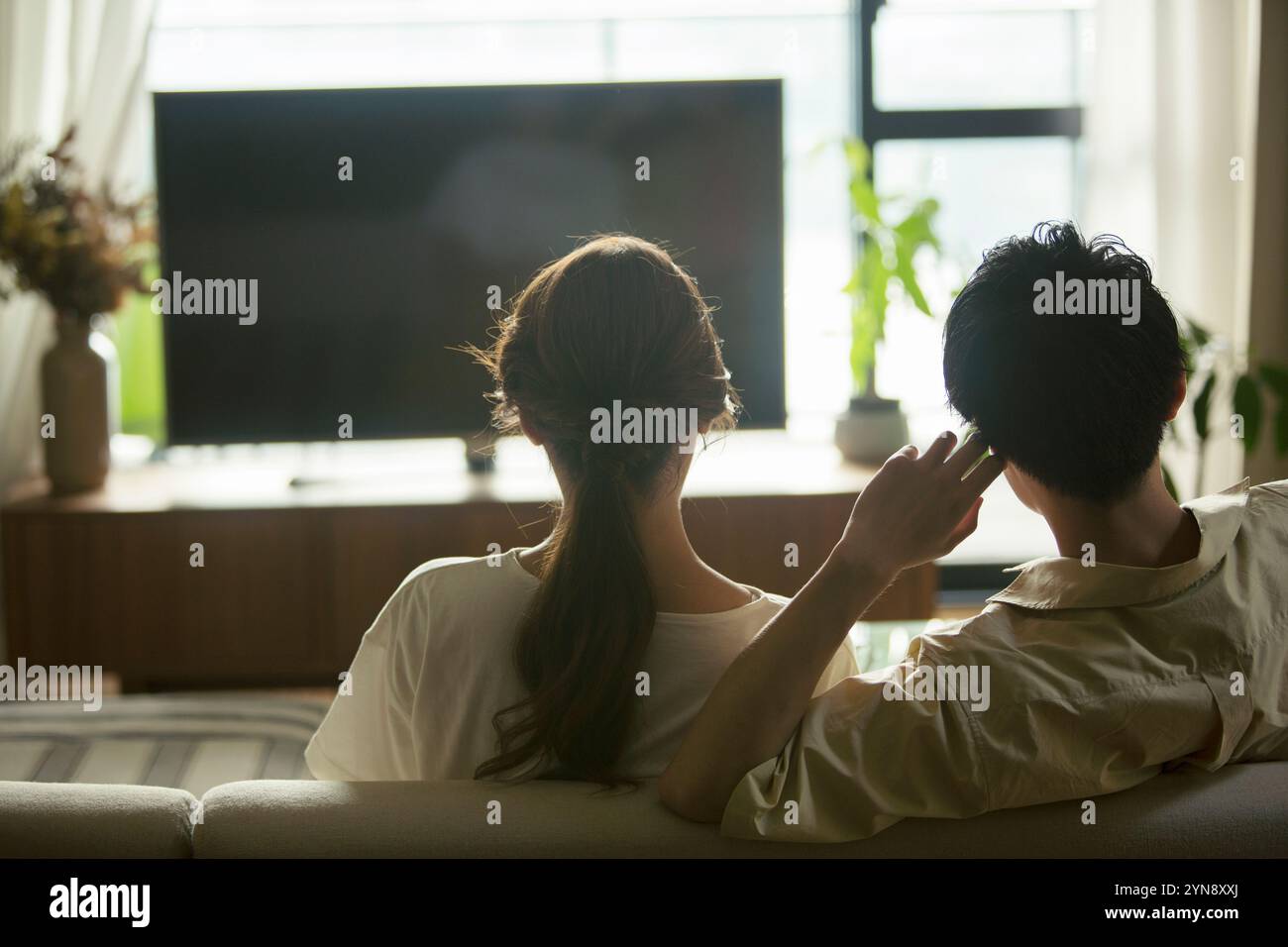 Back view of a couple in their 20s relaxing in their room Stock Photo ...
