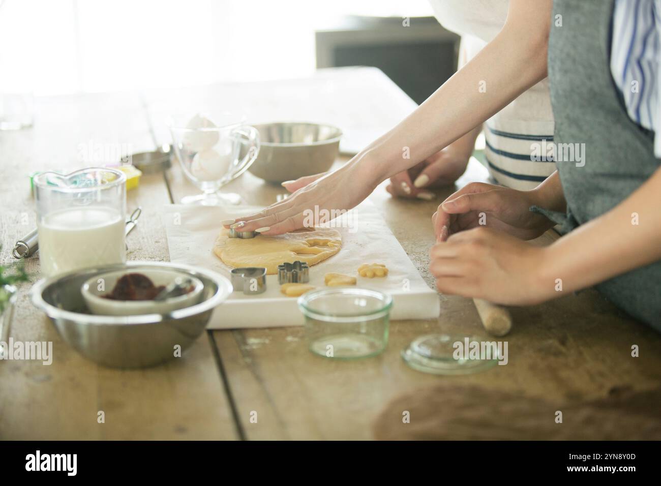 Two women in their 20s stamping out cookie moulds Stock Photo - Alamy