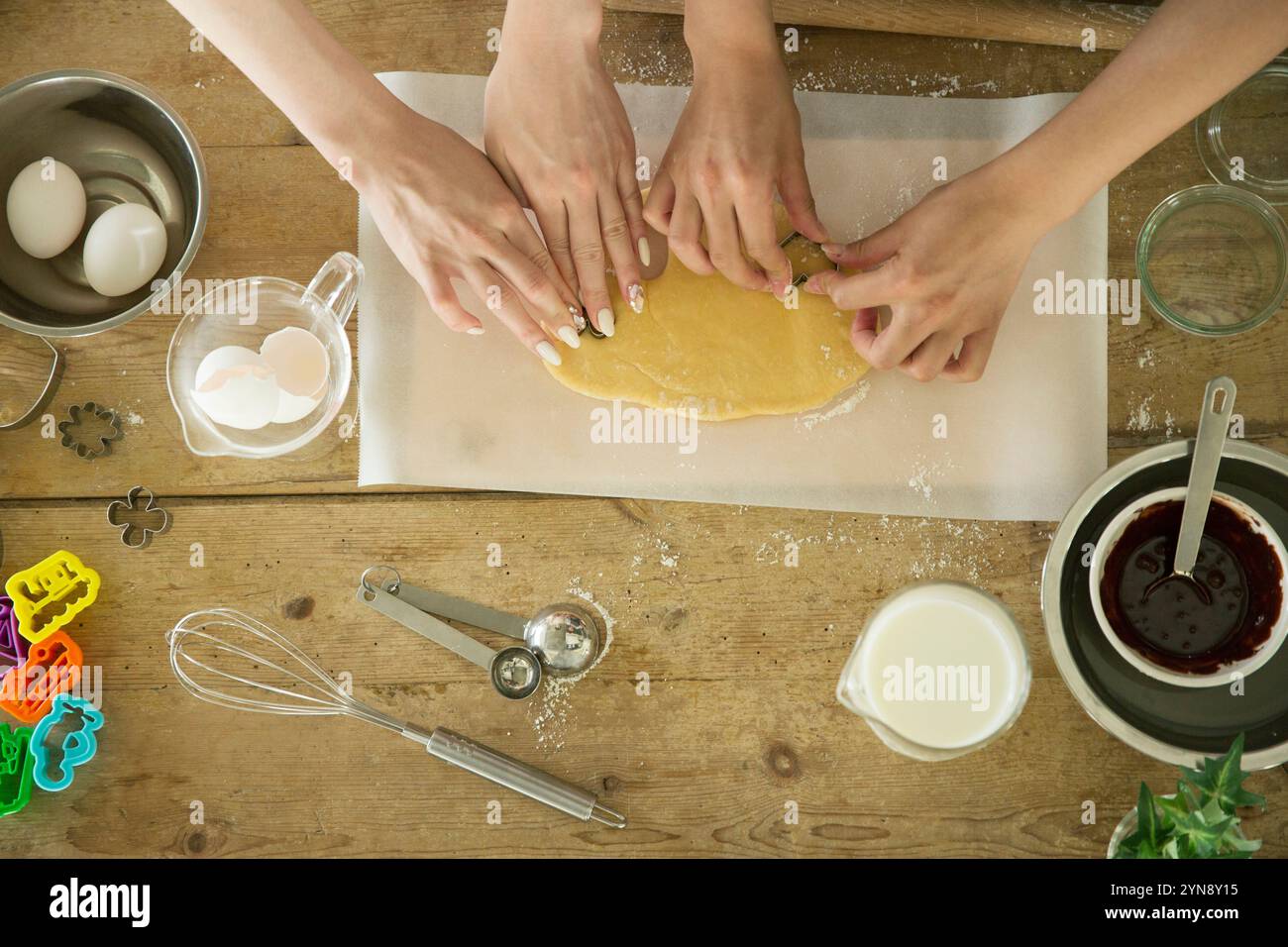 Two women in their 20s stamping out cookie moulds Stock Photo - Alamy