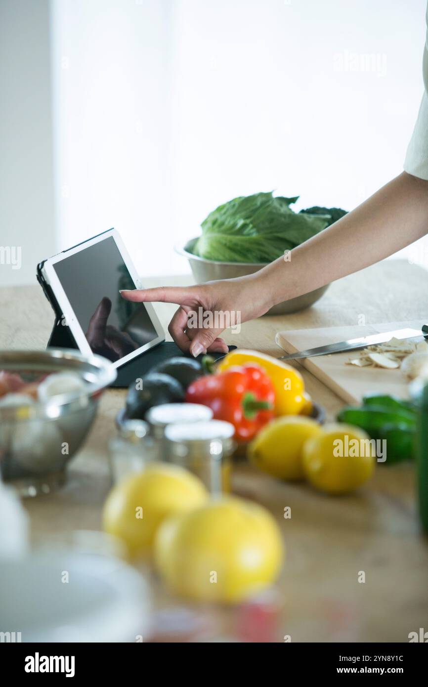 Vegetables and fruits on a stand and a woman's fingertips pressing a ...