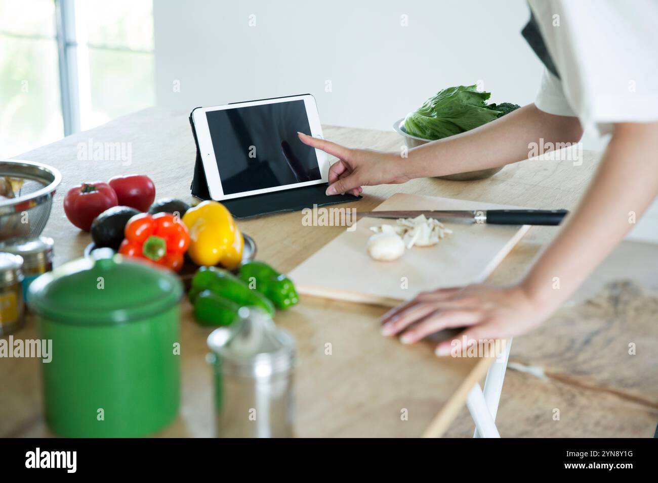 Vegetables and fruits on a stand and a woman's fingertips pressing a ...