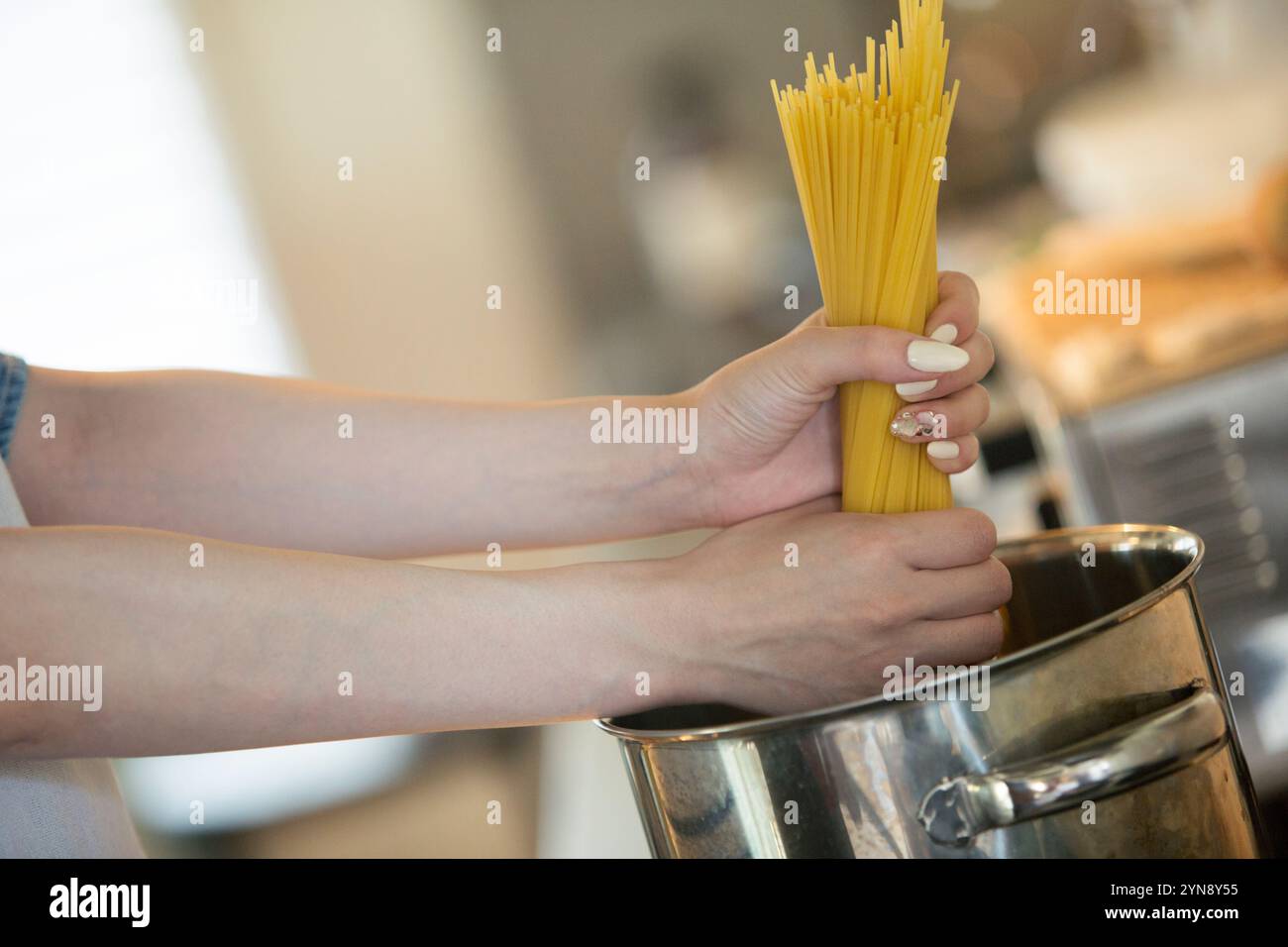 Woman's hand putting pasta into the pot Stock Photo - Alamy