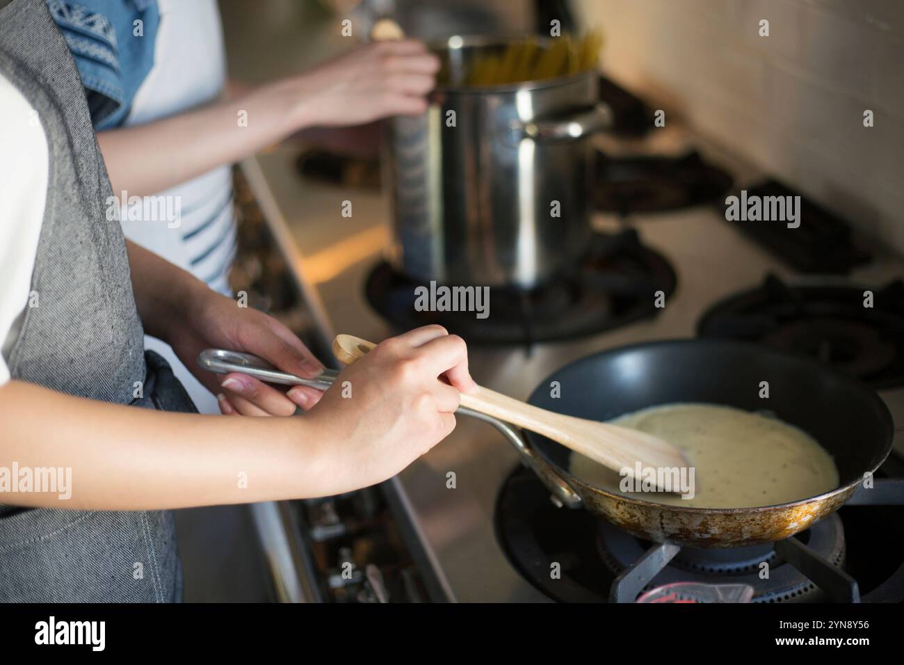 Two women cooking, hands in front of them Stock Photo - Alamy