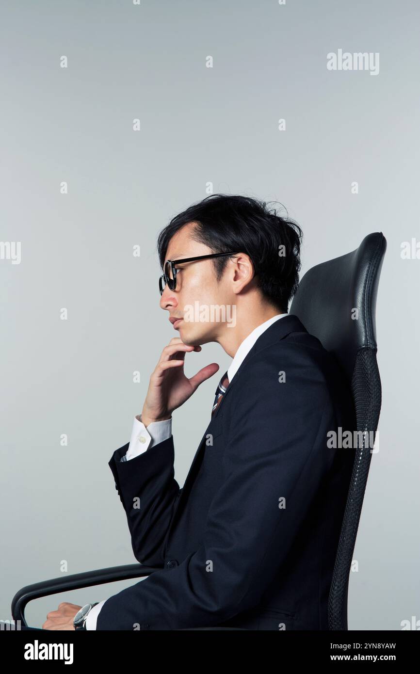Portrait of man in profile sitting on chair with cheekbones Stock Photo ...