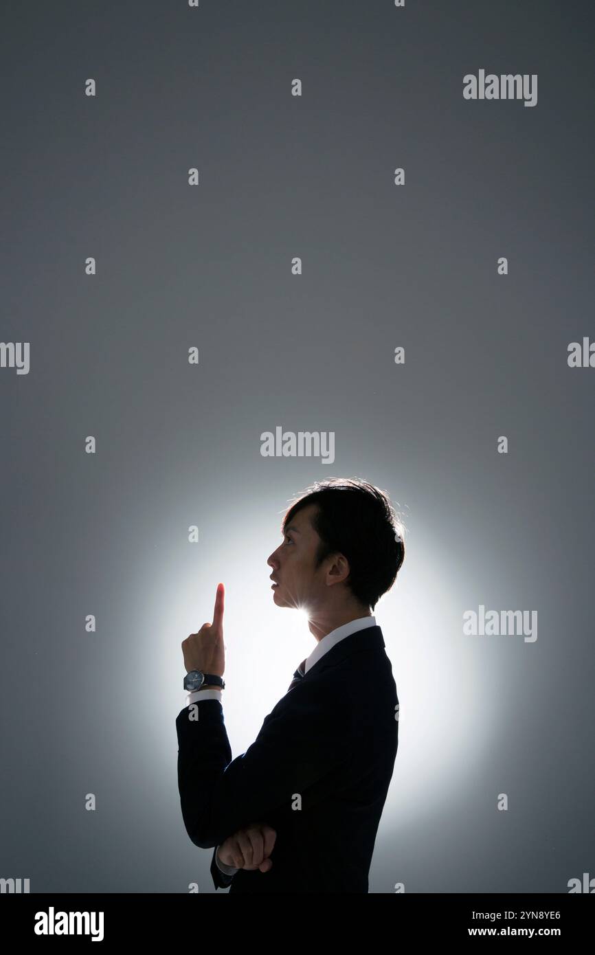 Profile of man in suit holding up index finger Stock Photo - Alamy