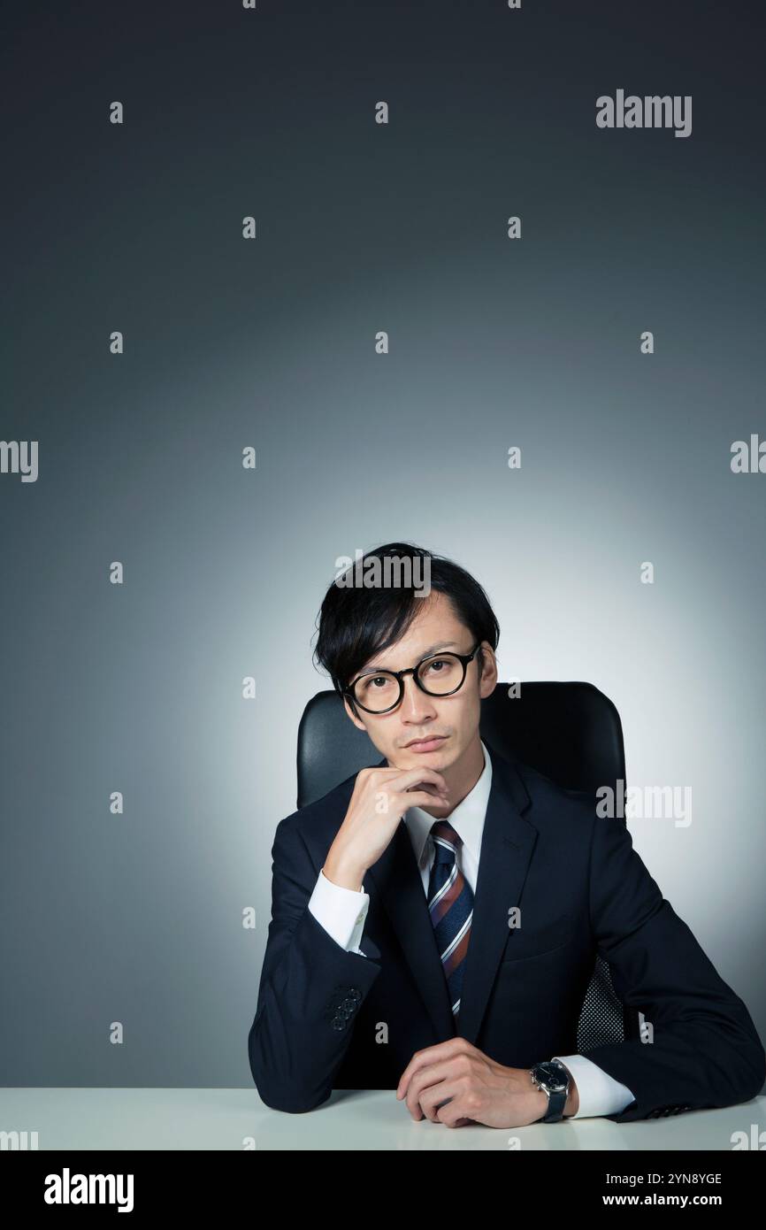 Portrait of a man thinking, resting on his elbows Stock Photo - Alamy